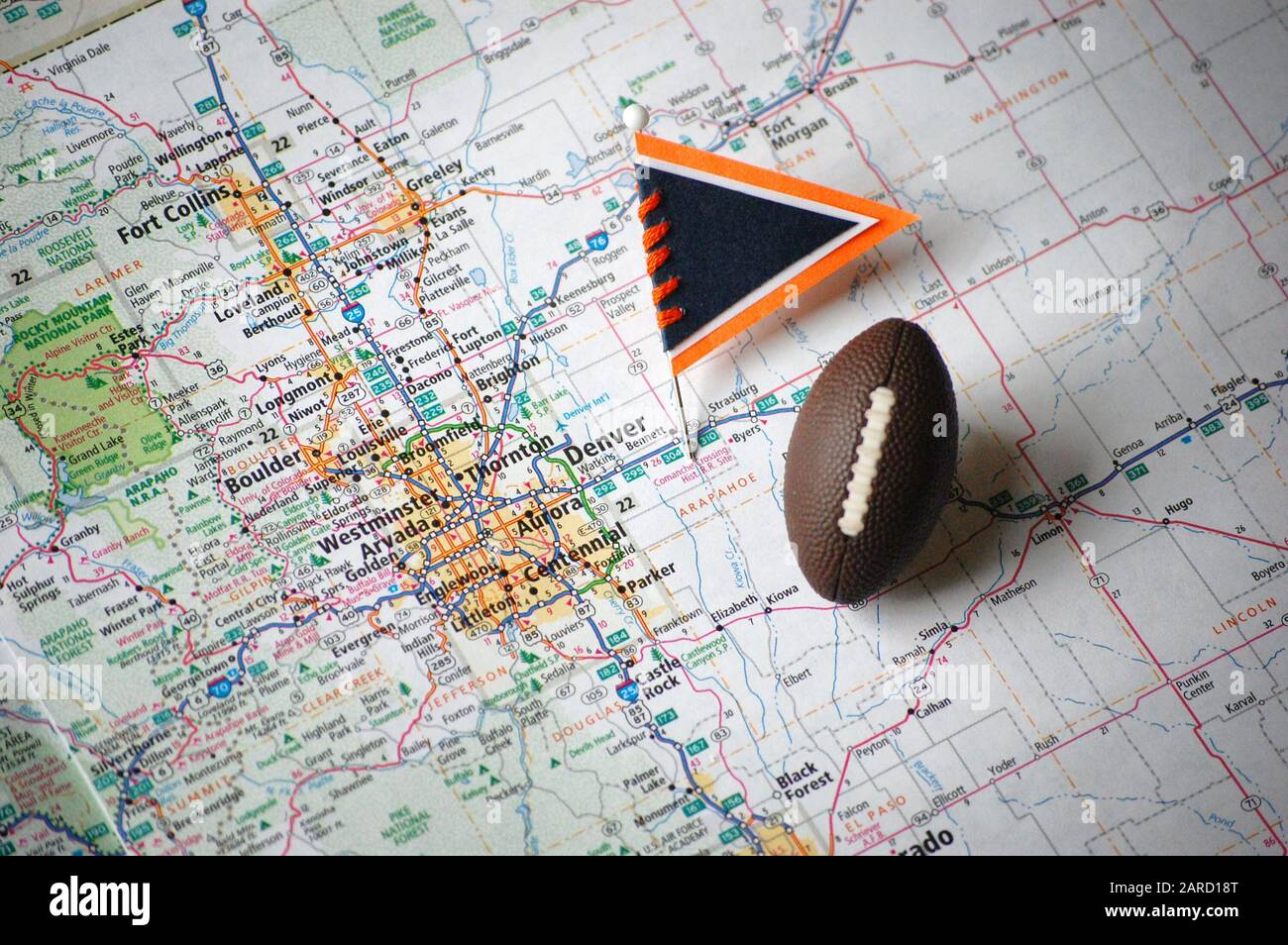 Macro shot of a flag and football placed on Denver, Colorado in a map ...