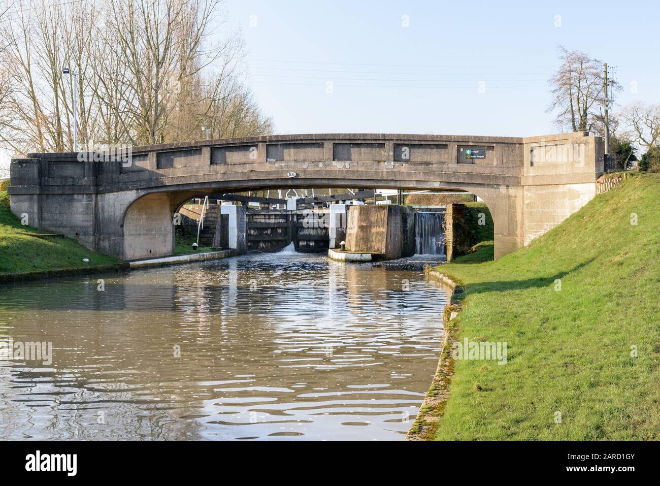 Hatton Locks, with a bridge, water and grass, a blue sky and winter ...