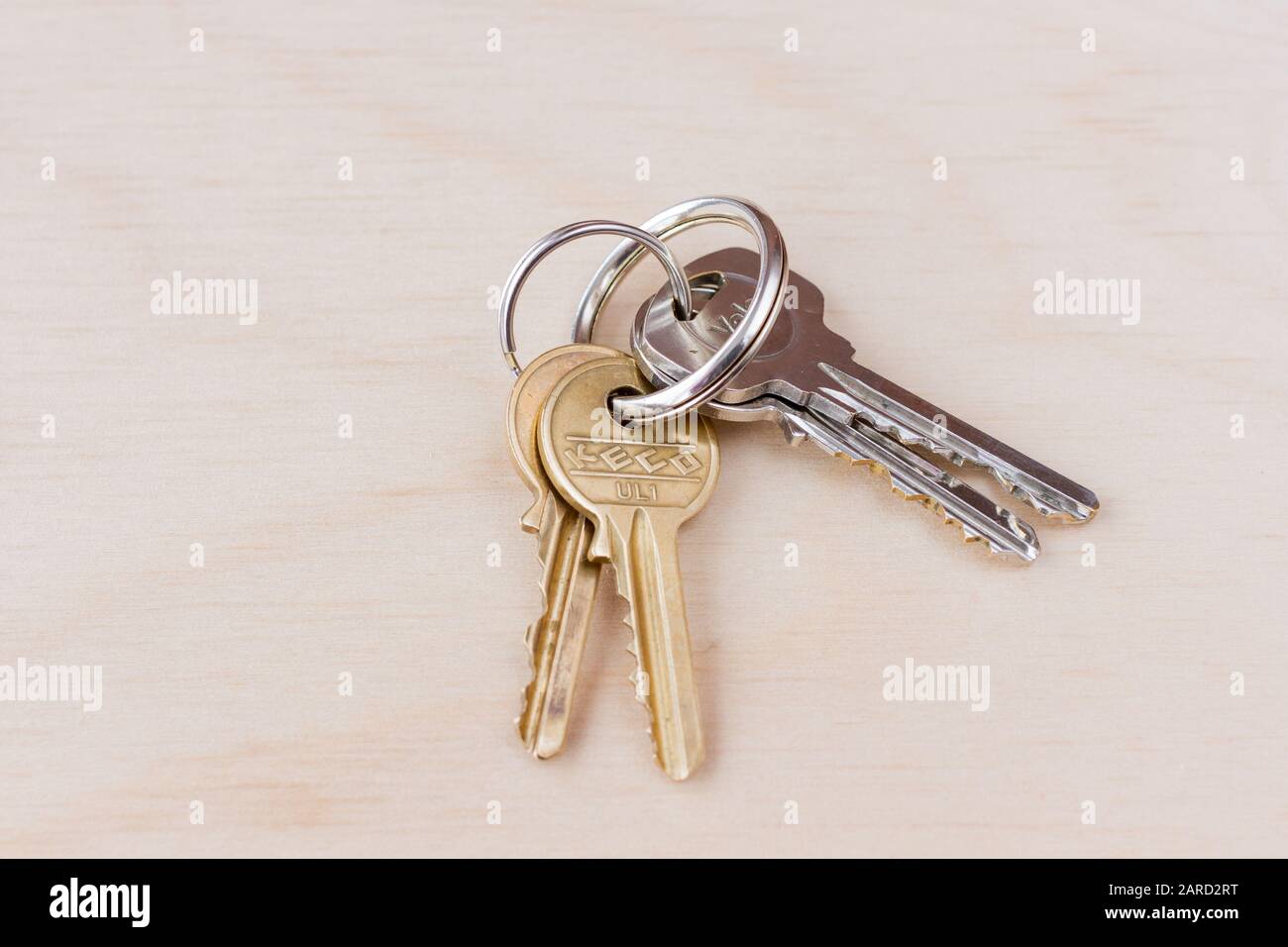 Bunch of four house keys on a light wooden background Stock Photo - Alamy