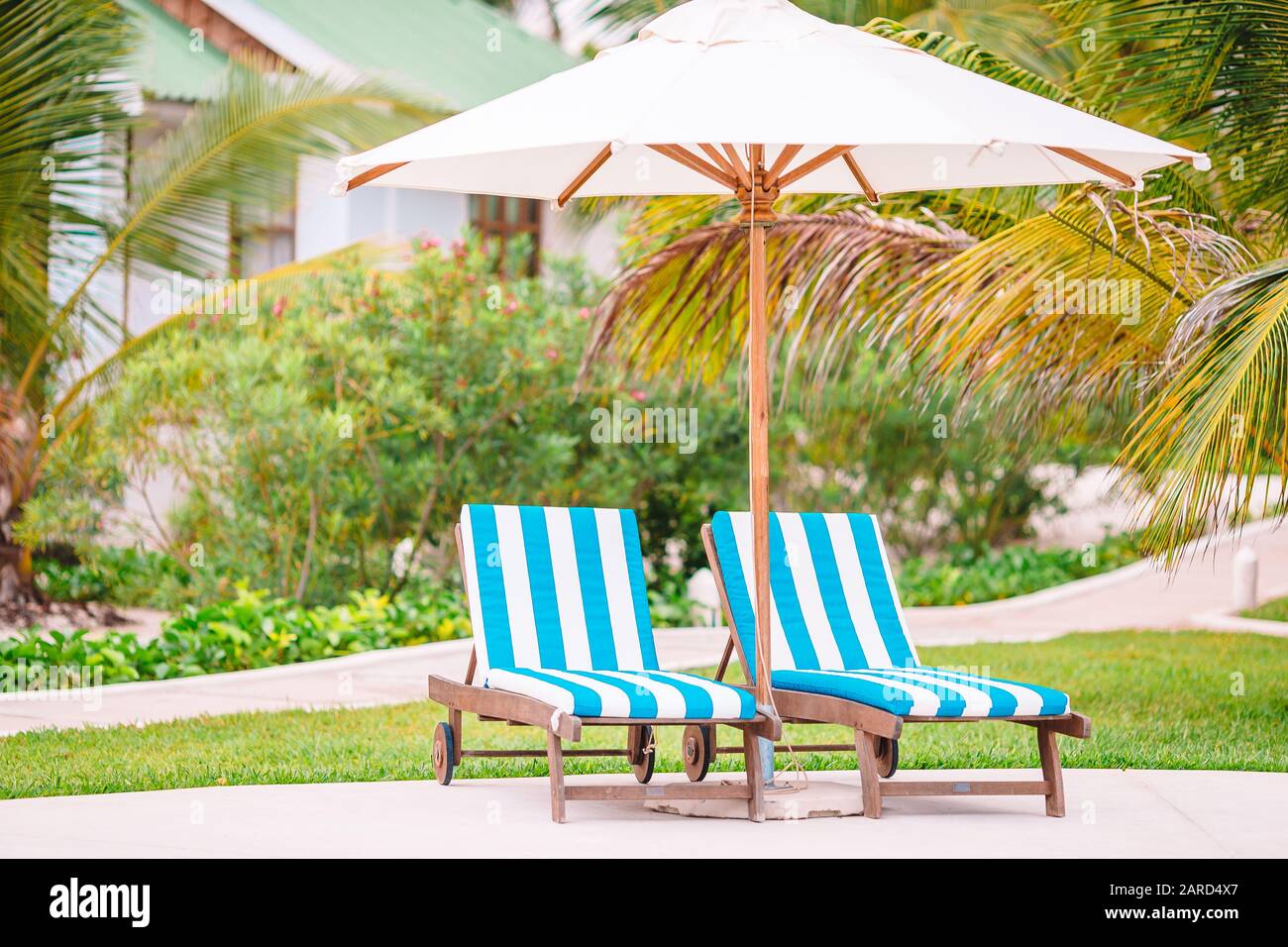 Beach lounge chairs on beautiful tropical luxury resort Stock Photo - Alamy