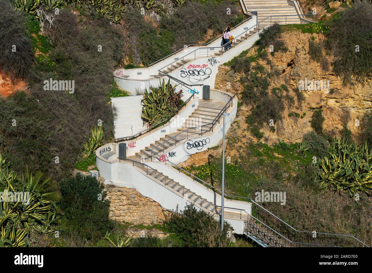 steep stone steps on the cliff leading down to the beach at Praia da ...