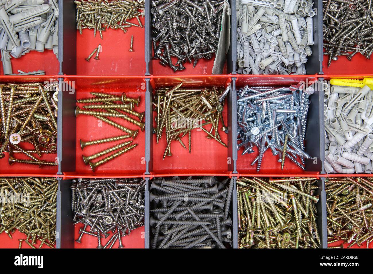 Top view on red tool box with square compartments with screws and ...