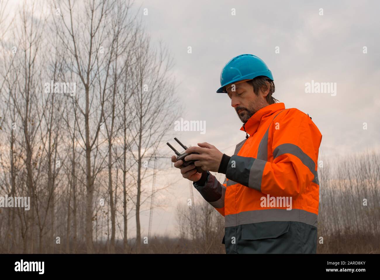 Forestry technician flying a drone with remote controller in woods and ...