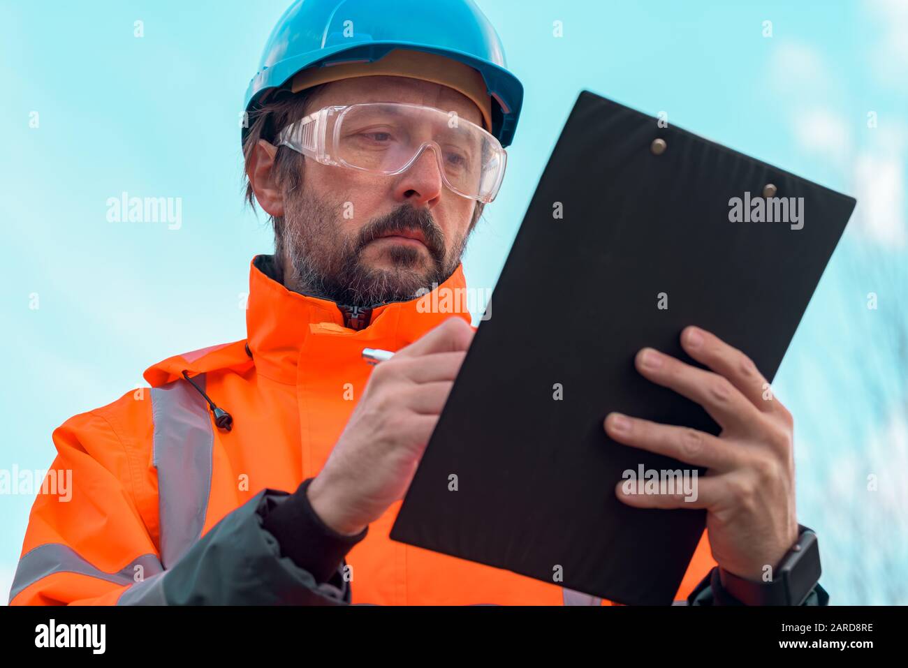 Forestry technician collecting data in forest and writing notes at ...