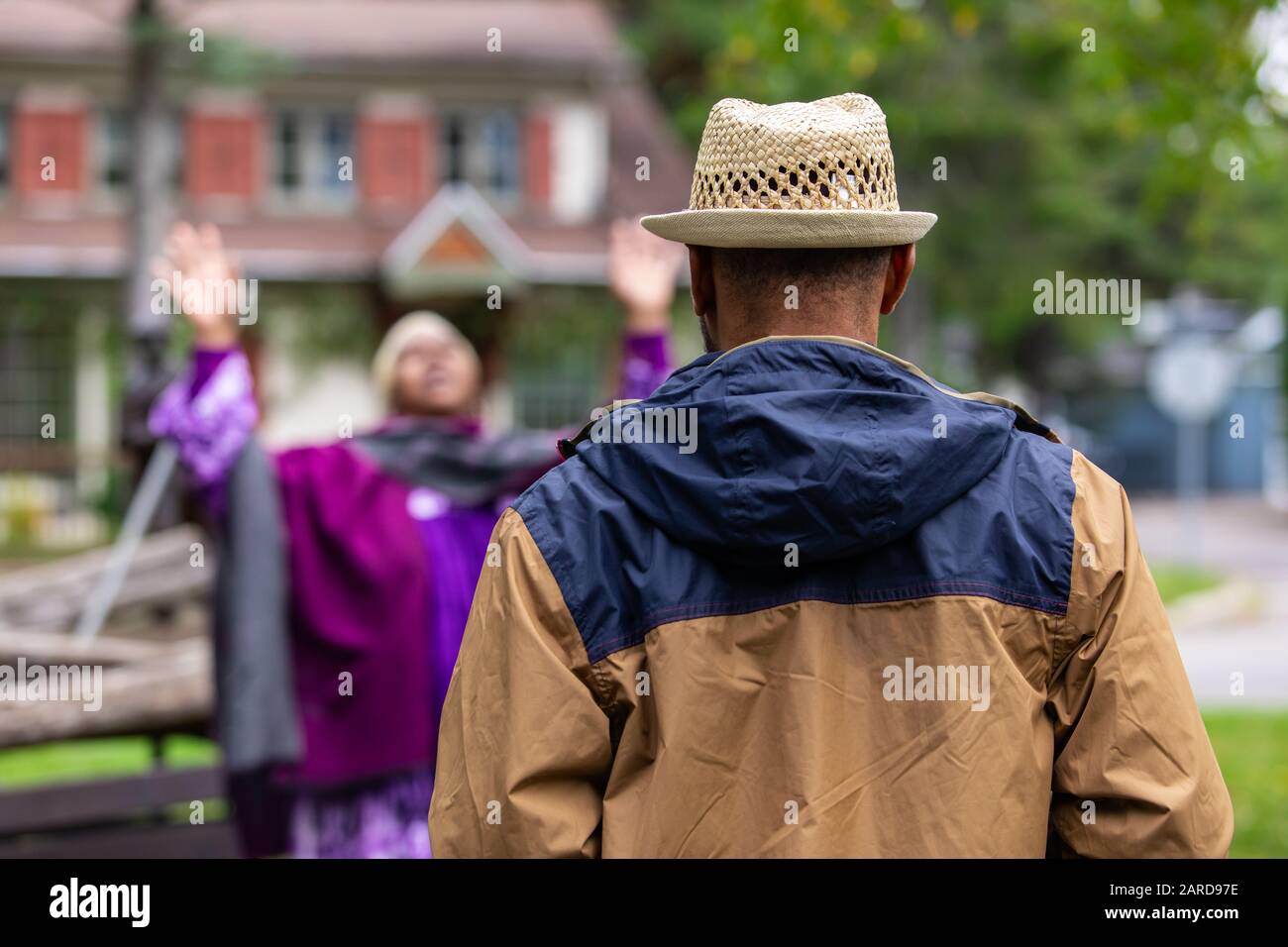 Rear view of man with wicker hat wearing jacket and standing in front ...