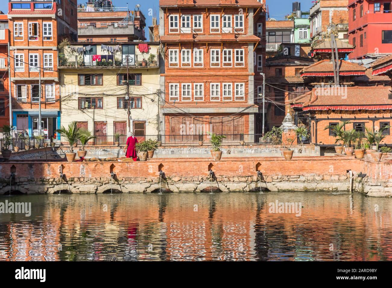 Colorful houses reflecting in the pond at the Pimbahal Pokhari Krishna ...