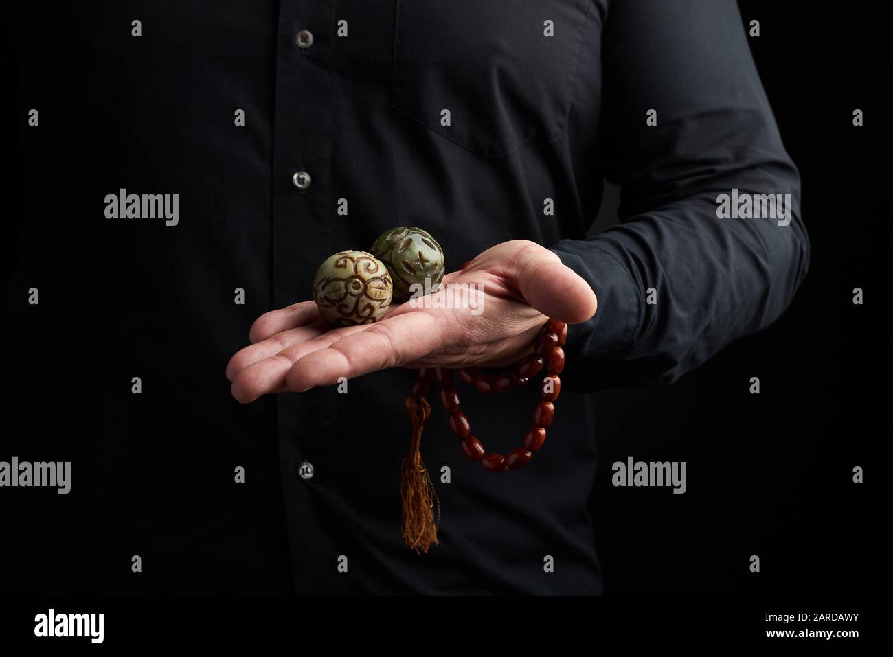 adult man in black clothes holds in his hands a magic ball, object for ...