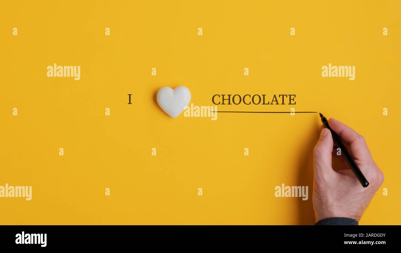 Male hand writing an I love chocolate sign with black marker over ...