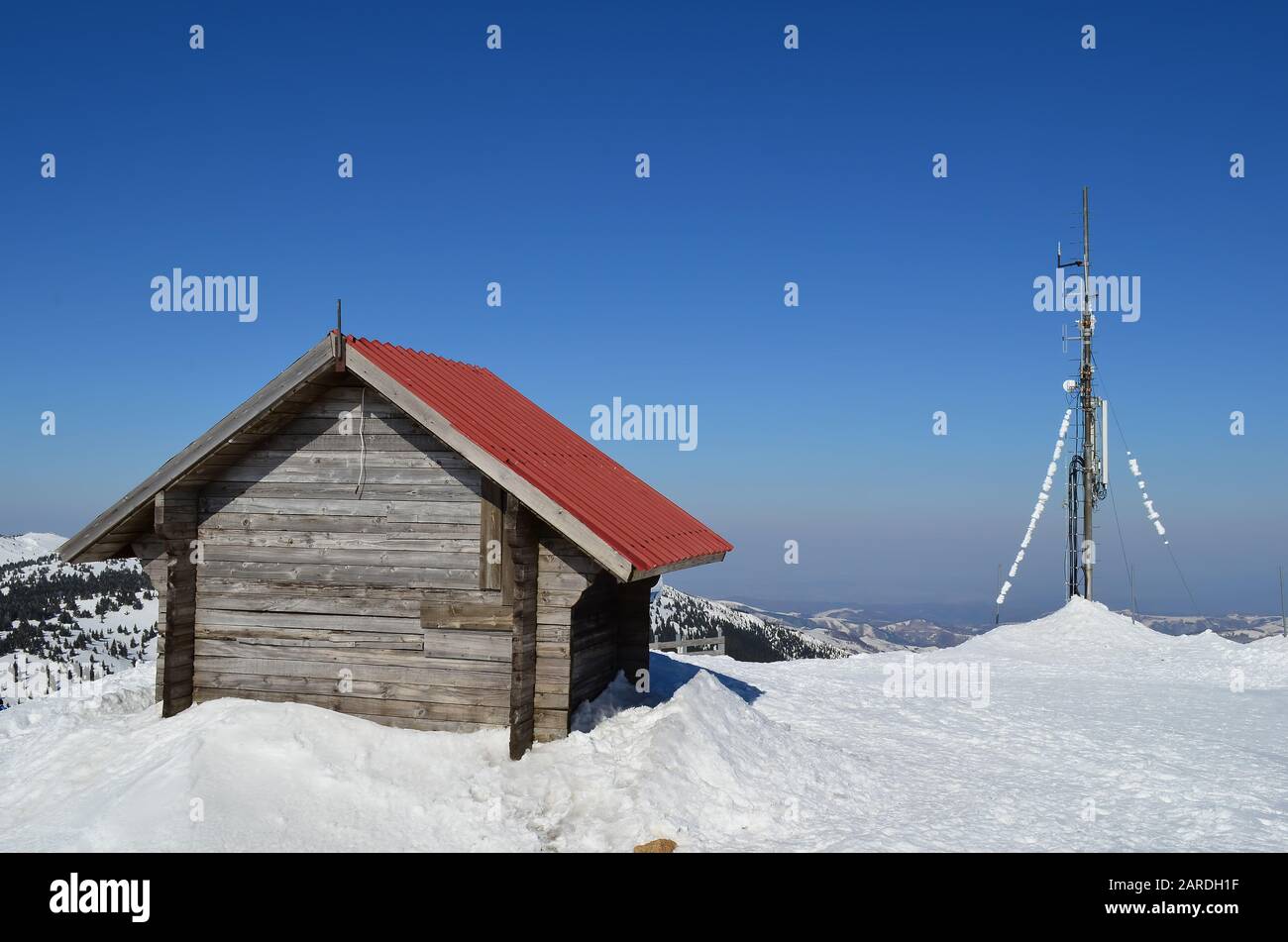 Small log house as a weather shelter and antenna on the top of mountain ...