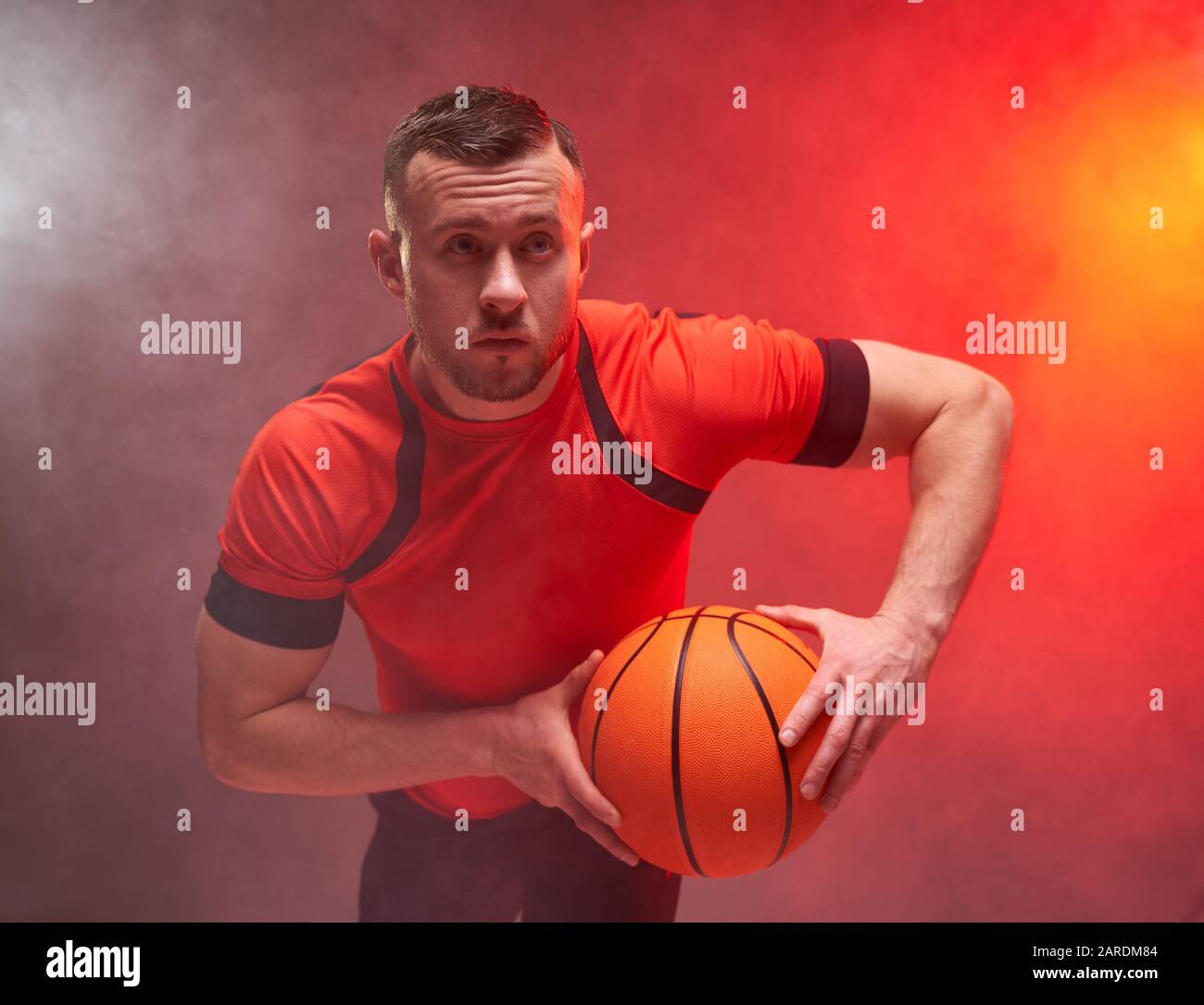 Young athletic basketball player in attack position holding ball with ...