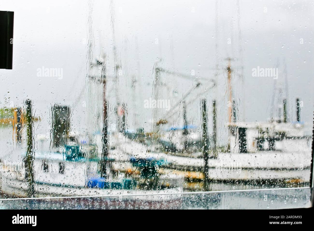 Fishing boats in Pelican Harbor, AK seen through rain-splattered window ...