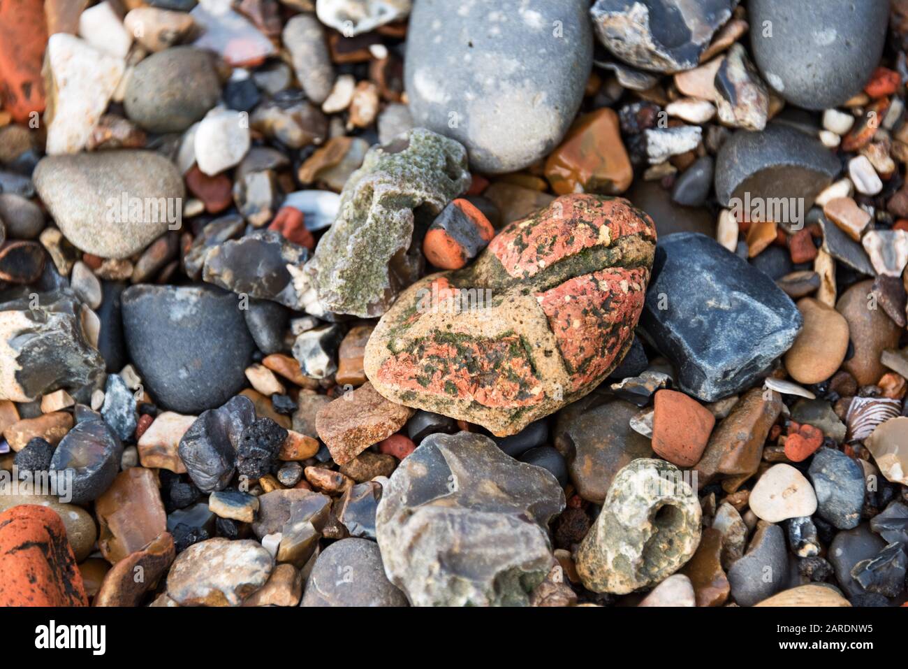 Brick rubble tumbled into a pebble shape, with fragments of flint and ...