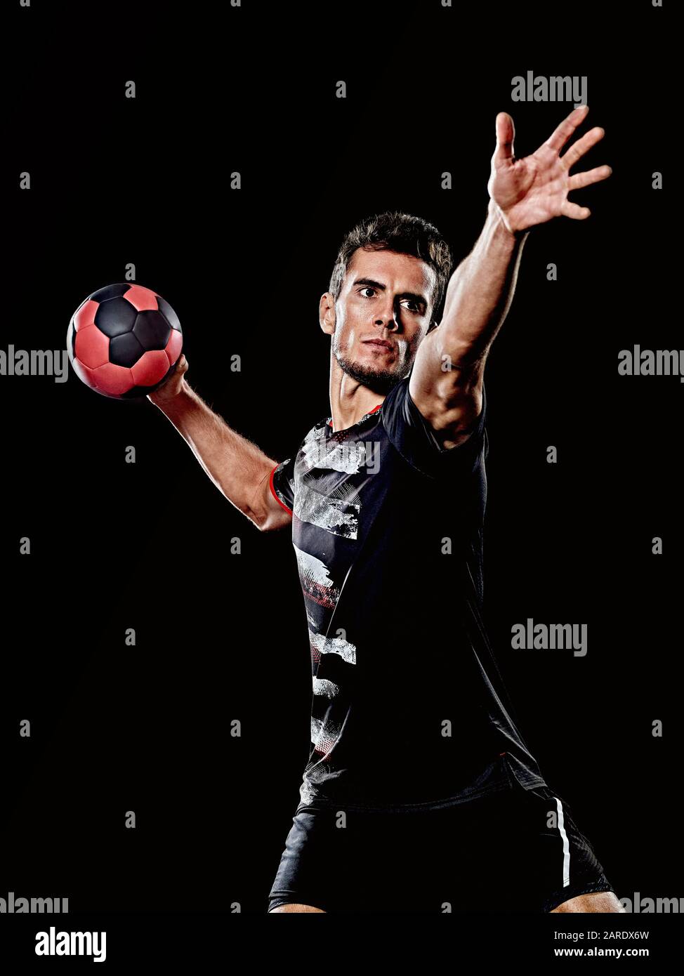 one caucasian young handball player man in studio isolated on black ...