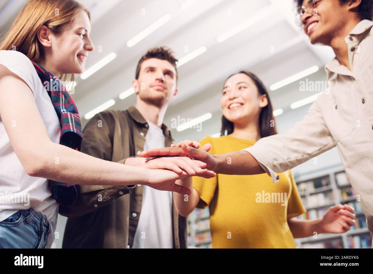 University Students put their hands together. Concept of teamwork and ...