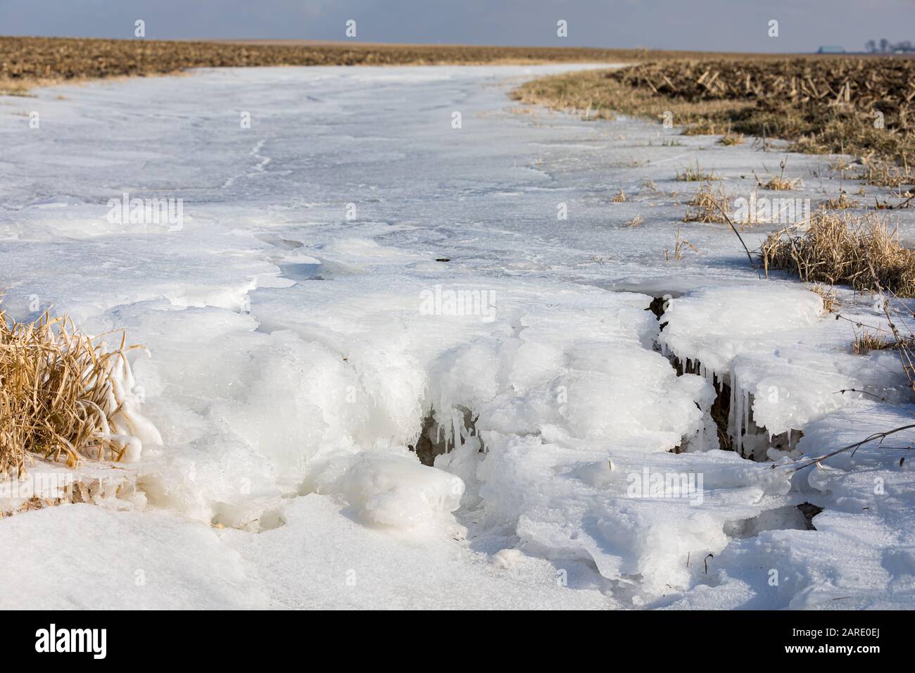 Farm field after heavy winter rain storms with water turning to ice as ...