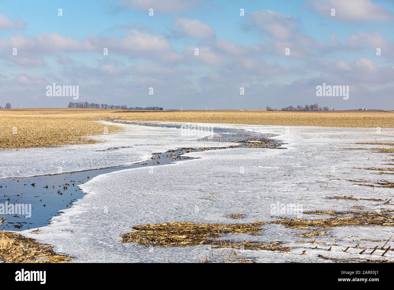 Farm field after heavy winter rain storms with water turning to ice as ...