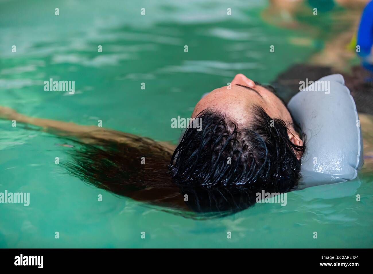 Handsome man floating in pool hi-res stock photography and images - Alamy