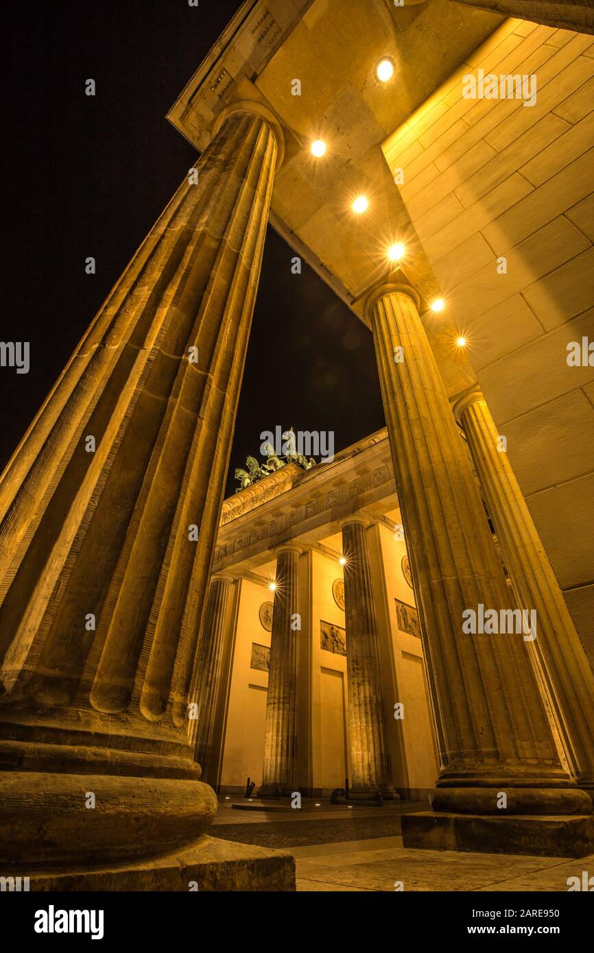 Vertical shot of a buildings with pillars at night time Stock Photo - Alamy