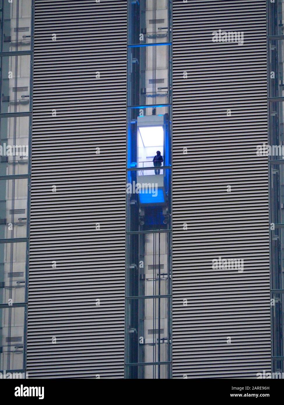 Vertical shot of a moving outdoor glass elevator of a modern building ...