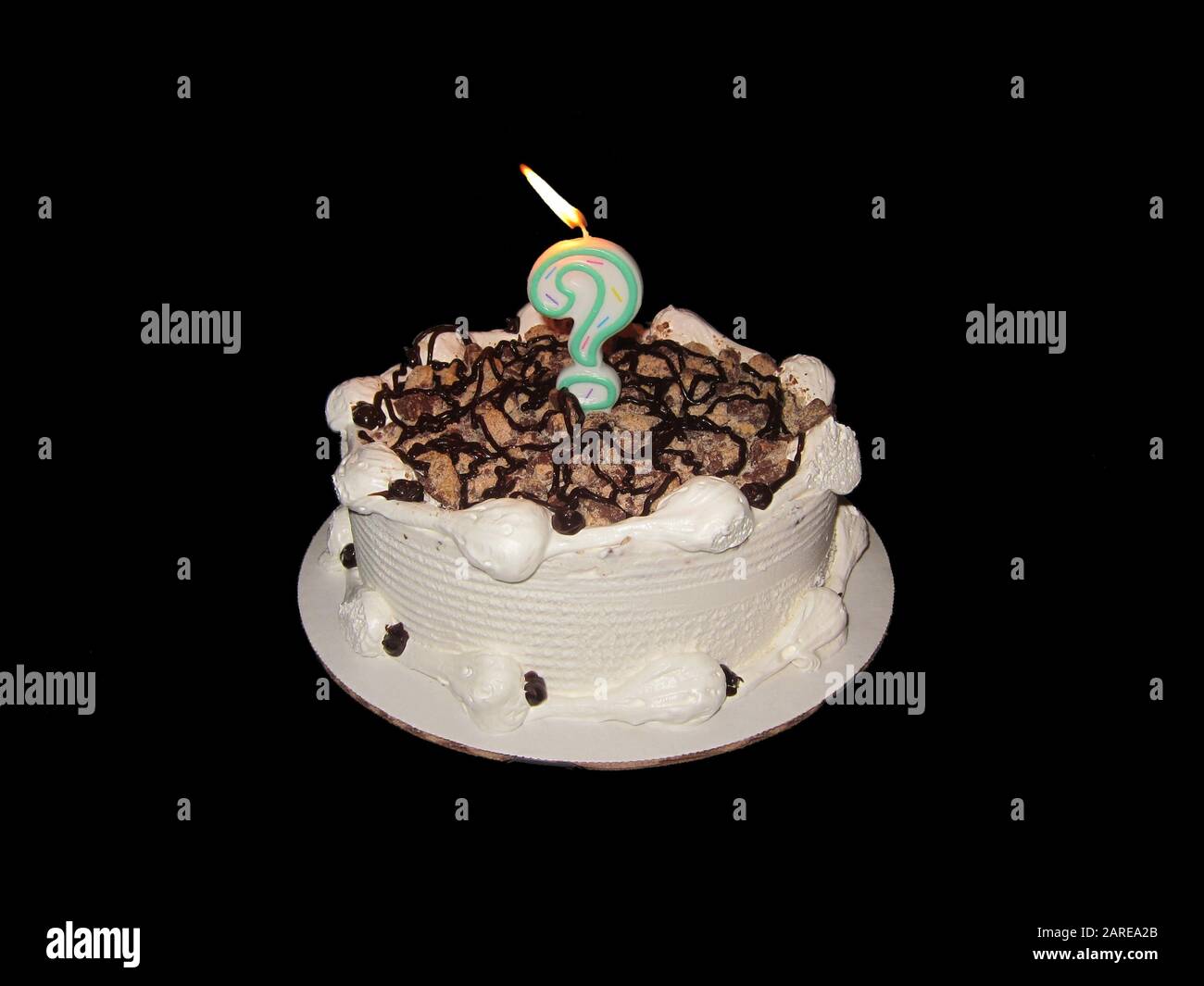 Overhead shot of a birthday cake with a question mark shaped candle ...