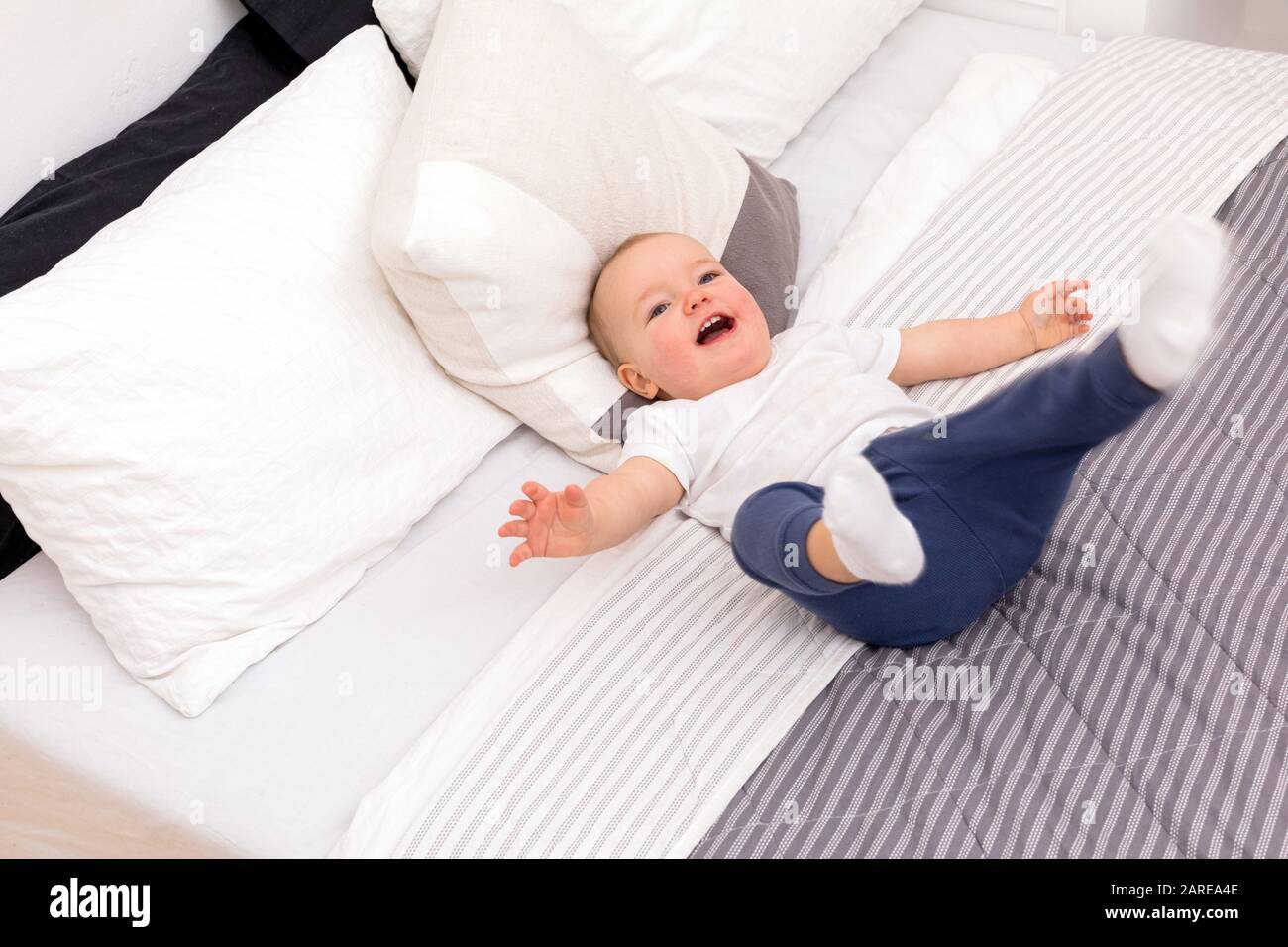 Content toddler smiling on bed Stock Photo - Alamy