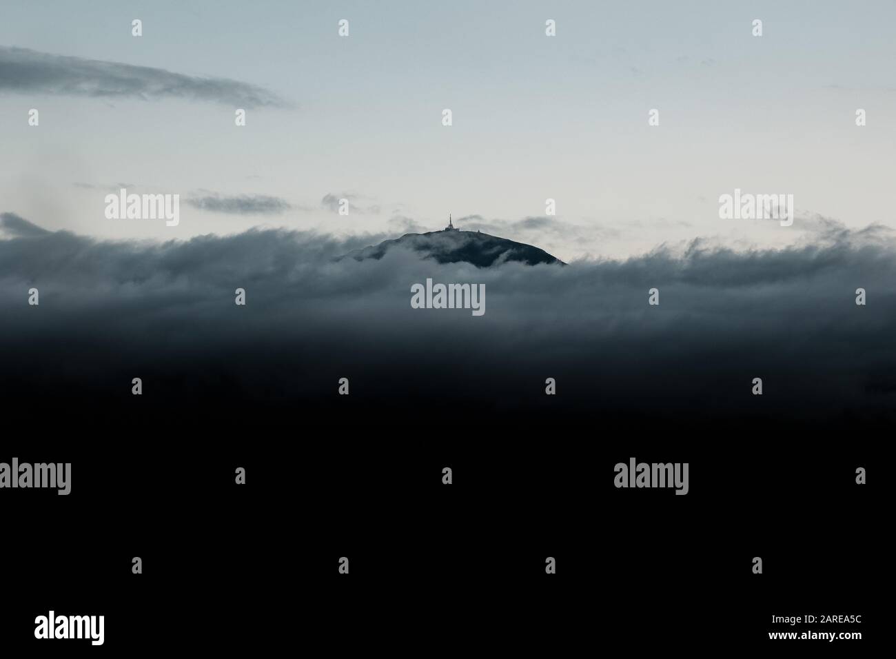 Hill covered in dark heavy clouds under a pale sky at daytime Stock ...