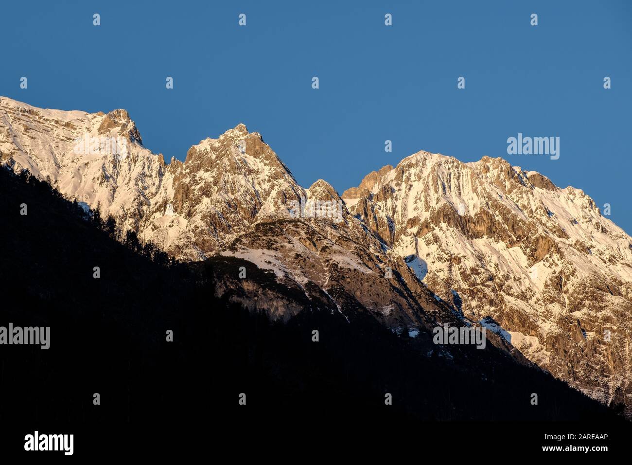 Landscape of rocks covered in greenery under the sunlight and a blue ...