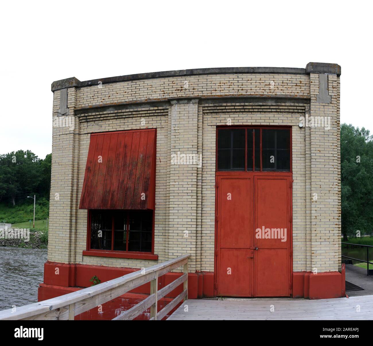 Closeup shot of a brick building in the river dam with a white sky in ...
