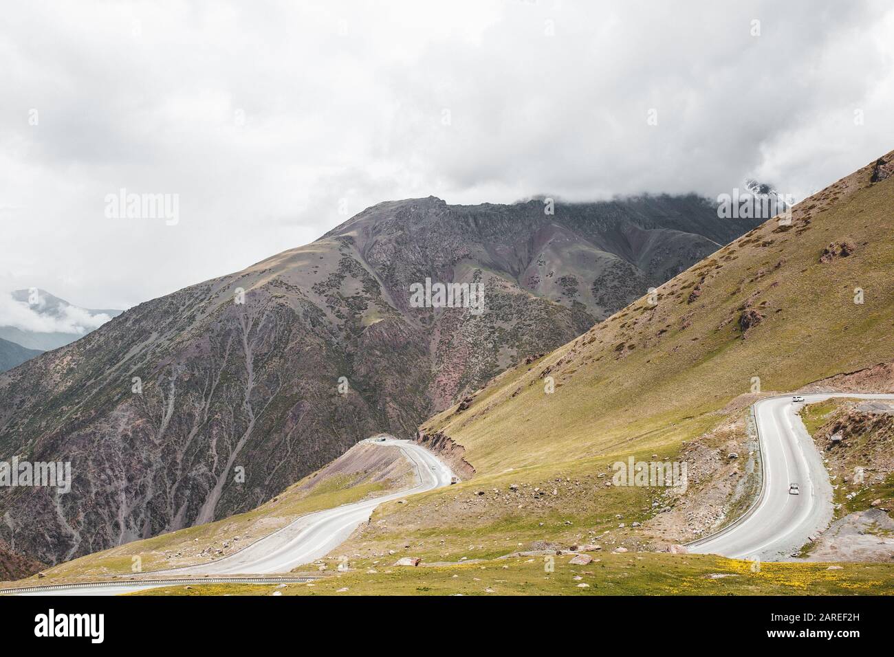 Landscape with mountains, clouds, water, and roads in a Central Asian ...