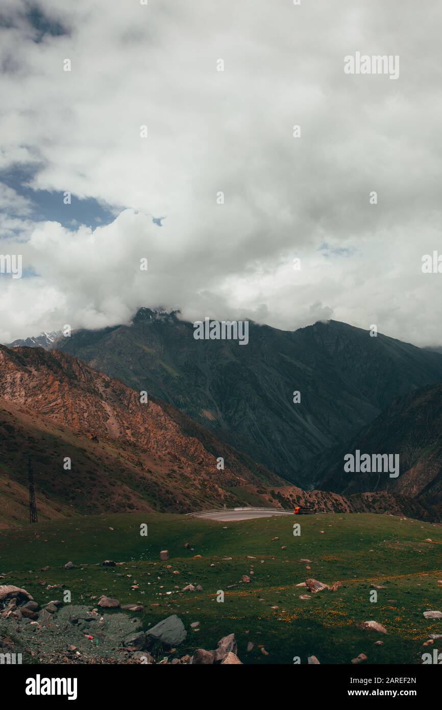 Landscape with mountains, clouds, water, and roads in a Central Asian ...