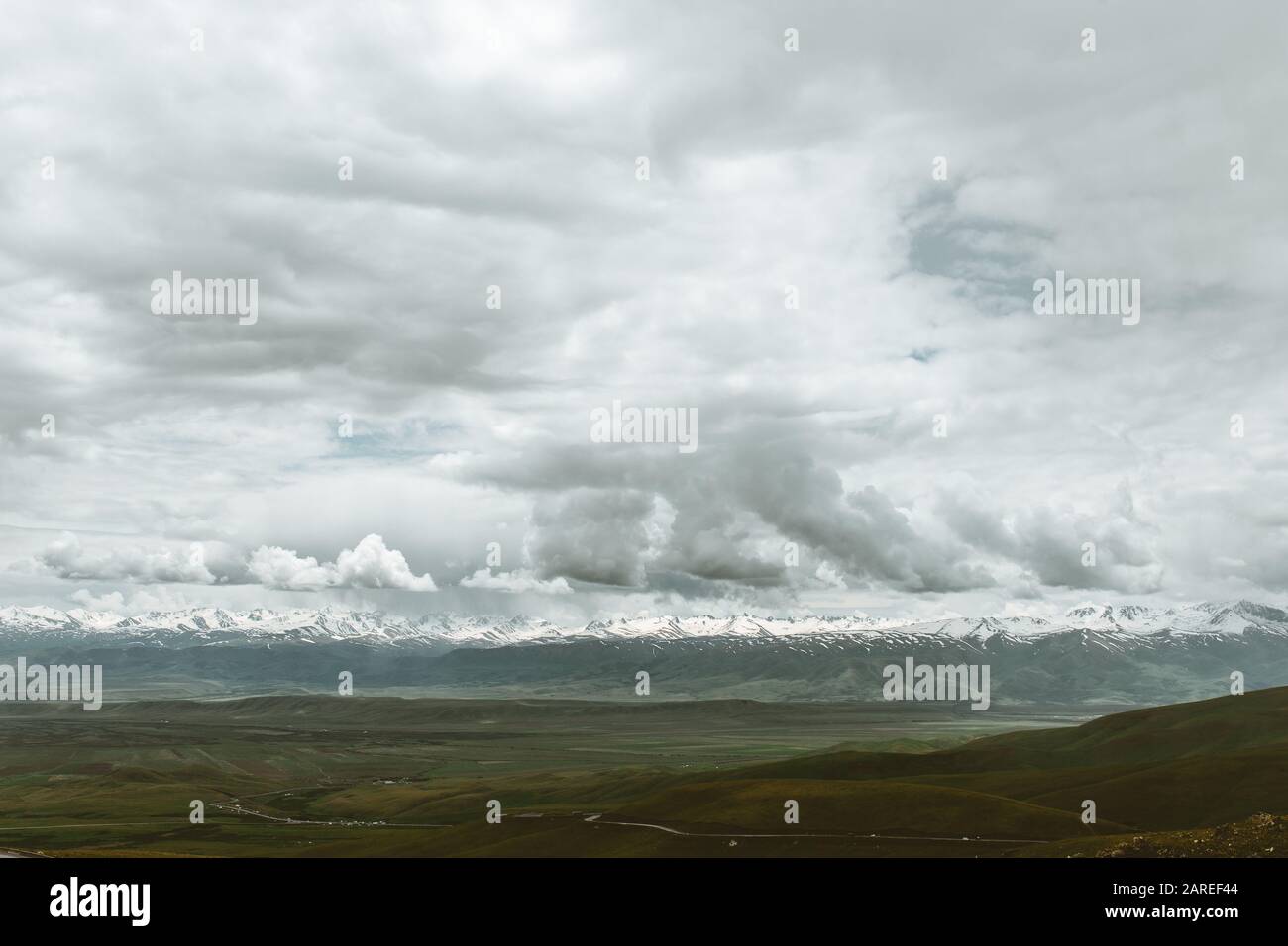 Landscape with mountains, clouds, water, and roads in a Central Asian ...