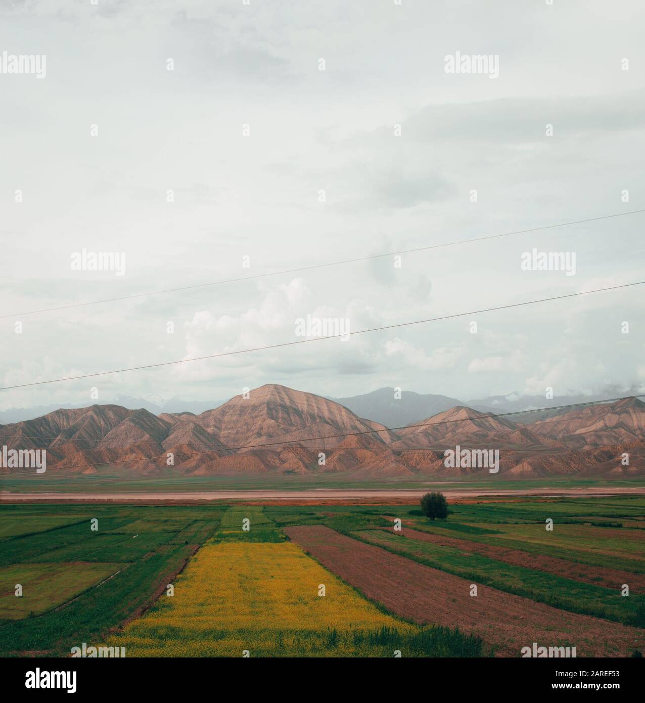Landscape with mountains, clouds, water, and roads in a Central Asian ...