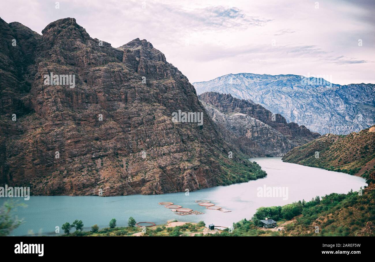 Landscape with mountains, clouds, water, and roads in a Central Asian ...