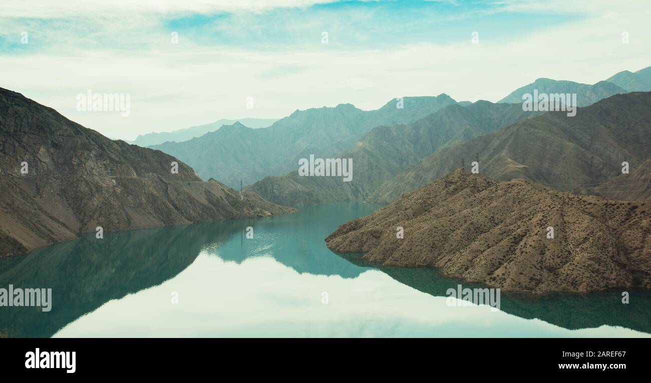Landscape with mountains, clouds, water, and roads in a Central Asian ...