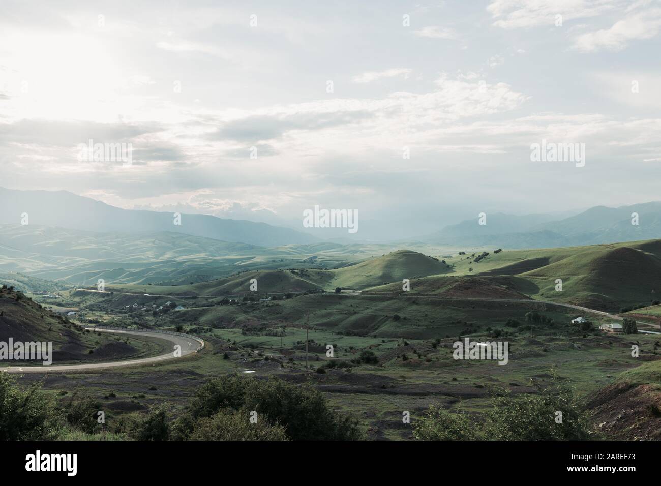 Landscape with mountains, clouds, water, and roads in a Central Asian ...