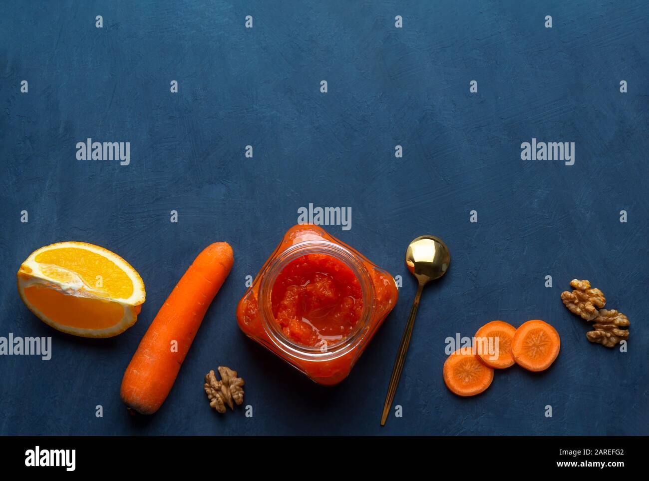 Vegetable jam of carrots in a jar against a dark background. Flat ...