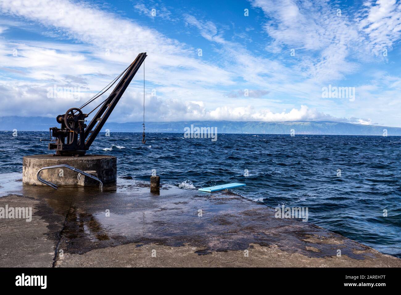 A crane on a boat ramp with Sao Jorge island in the distance on Pico in ...