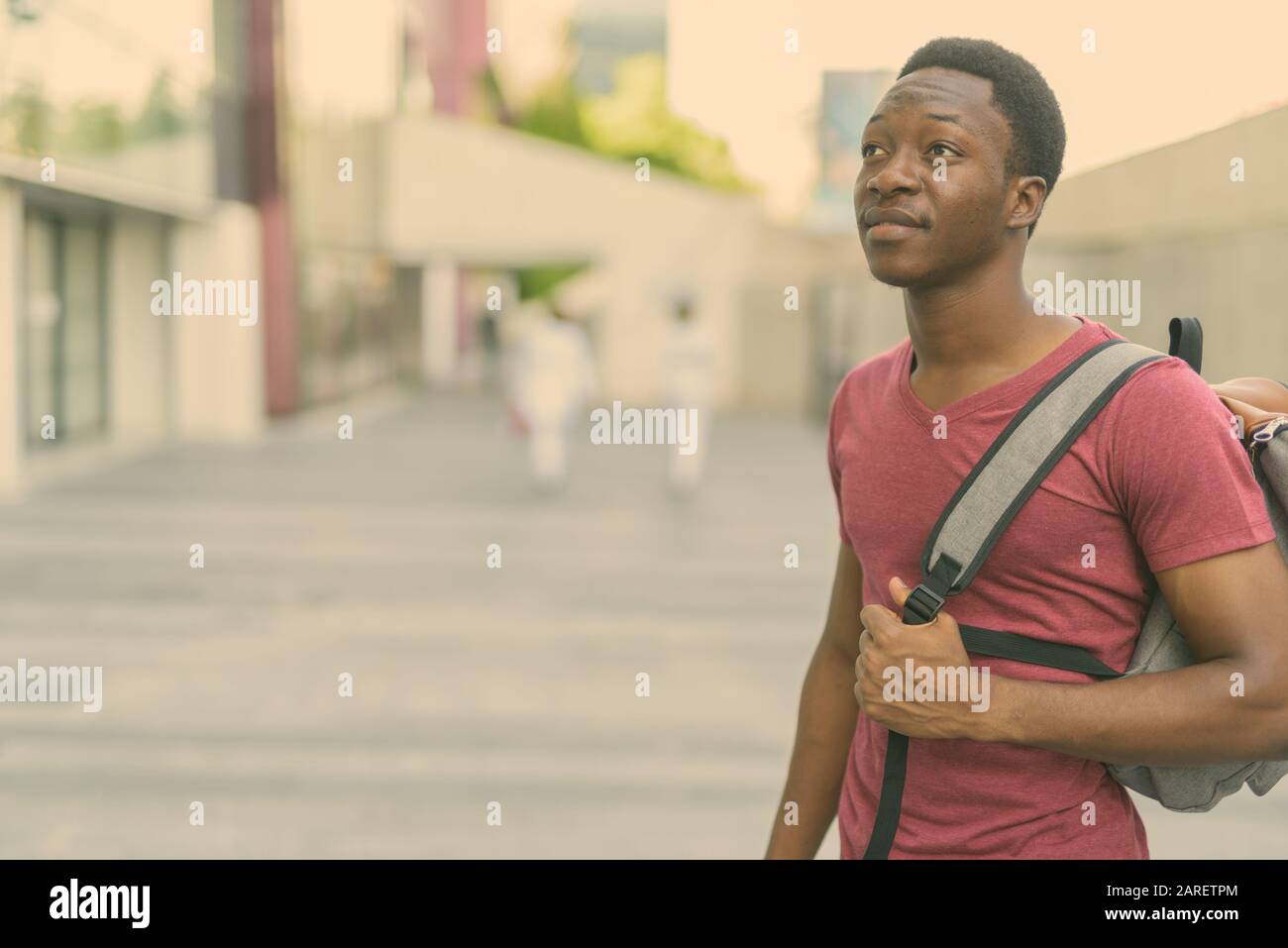 Young handsome African tourist man carrying backpack in the streets ...