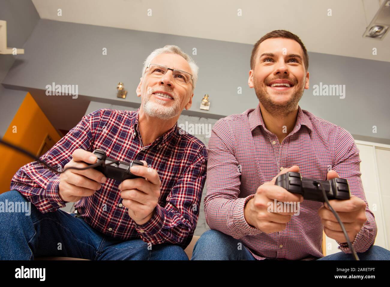 Two cheerful happy men playing video games with joysticks Stock Photo ...