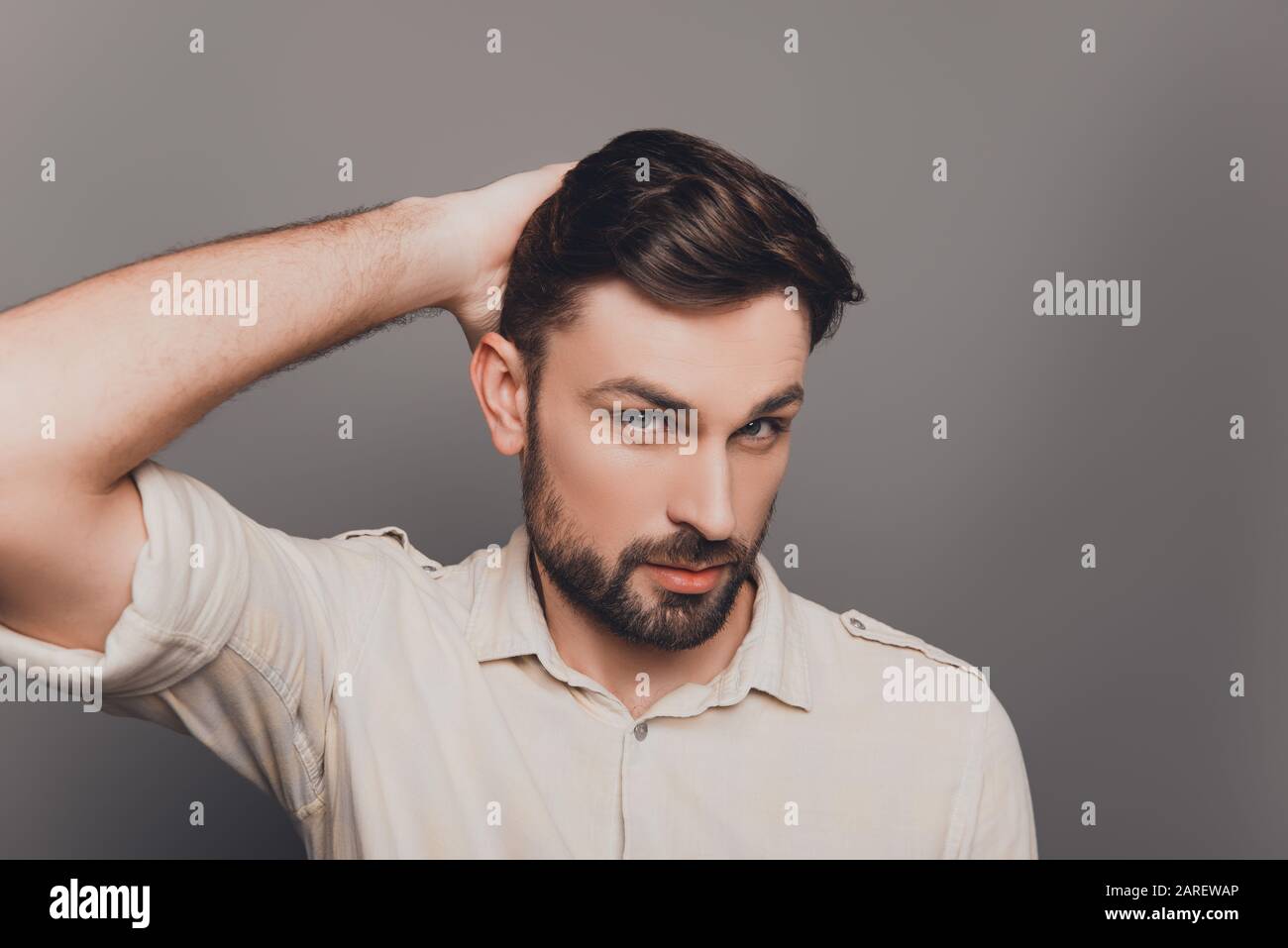 Portrait of handsome serious young man combing his hair Stock Photo - Alamy
