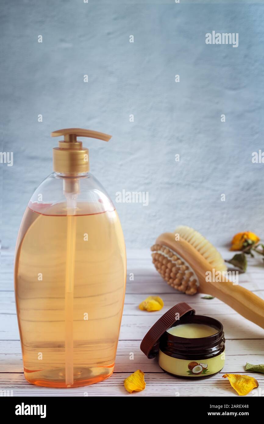 Shower gel, massage brush and skin cream Stock Photo - Alamy