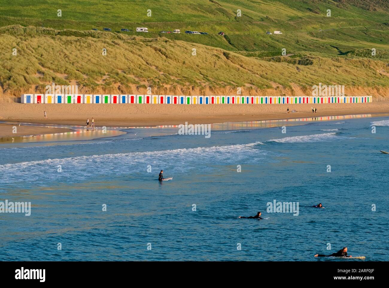 Saunton Sands beach with sand dunes and a line of colourful, painted ...