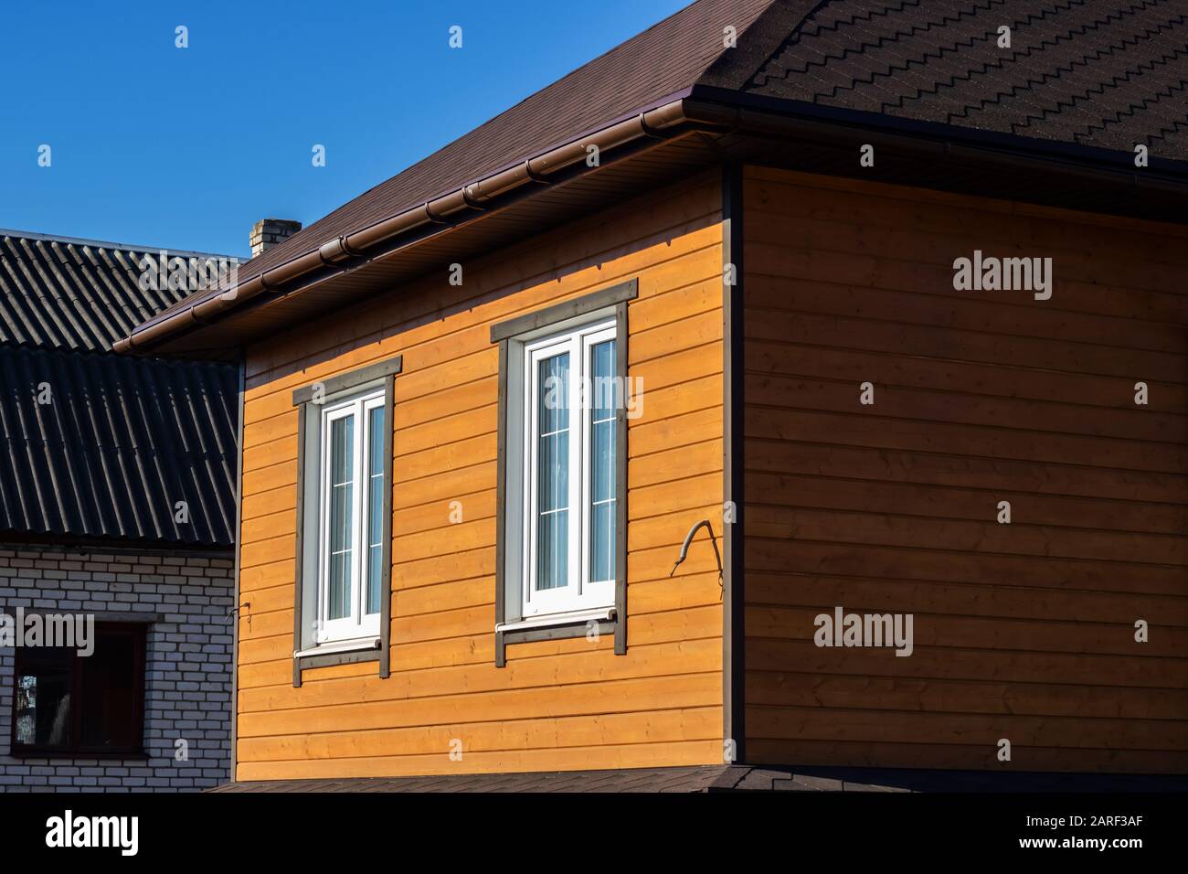 Exterior view of a new wooden house and two windows Stock Photo - Alamy