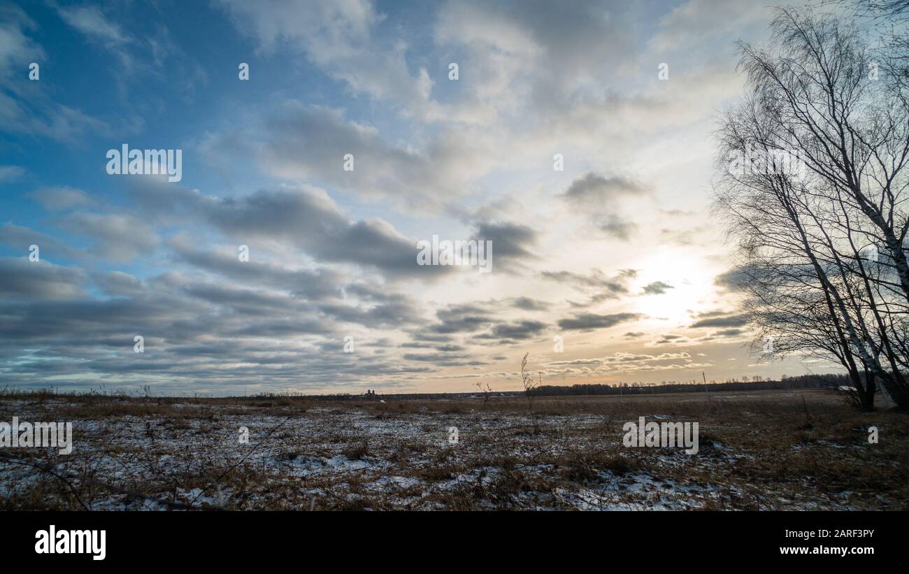 Beautiful setting sun over frozen field Stock Photo - Alamy