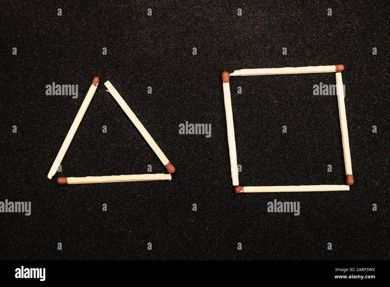 The triangle and square is made of matches on a black background close ...