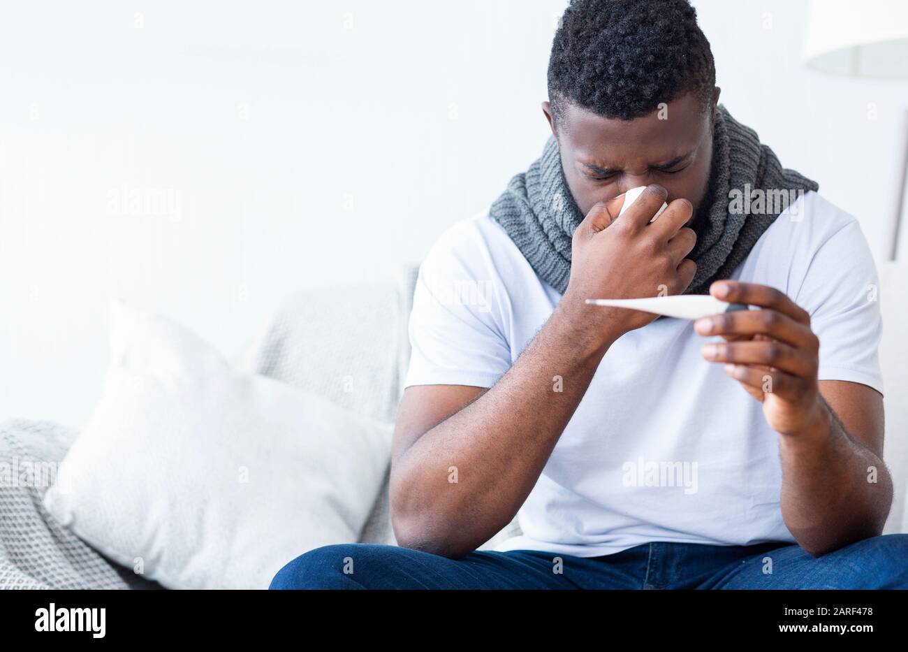 Sick african american guy holding thermometer, having fever Stock Photo ...
