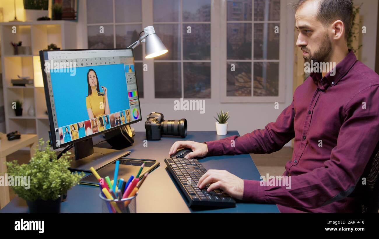 Male photographer edits photos in creative office. Software for ...
