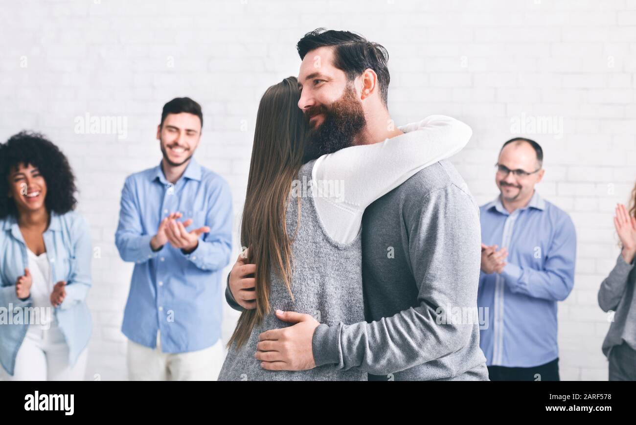 Happy people embracing during psychotherapy meeting, celebrating their ...
