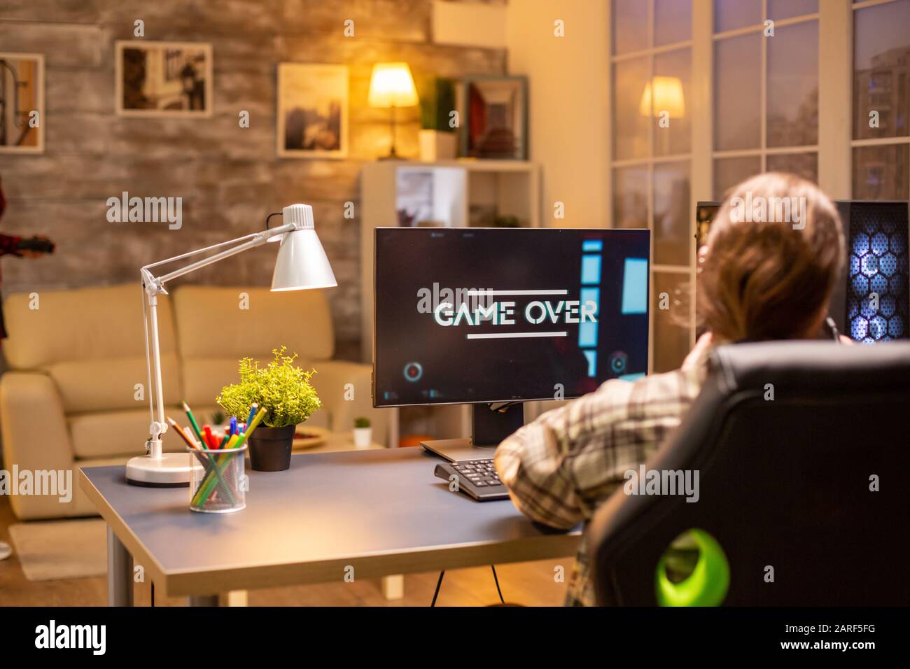 Professional male gamer playing on powerful PC and losing the game late ...