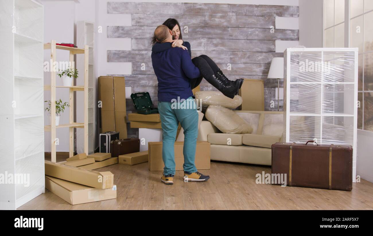 Excited boyfriend spinning his girlfriend in their new apartment ...